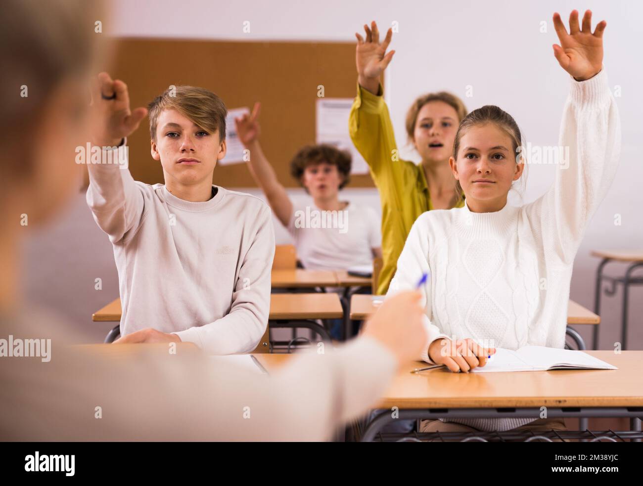 School girl raising arm teacher hi-res stock photography and images - Alamy