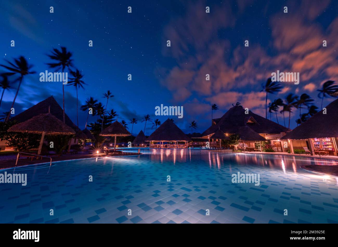 A beautiful swimming pool in tropical resort in the evening Stock Photo ...