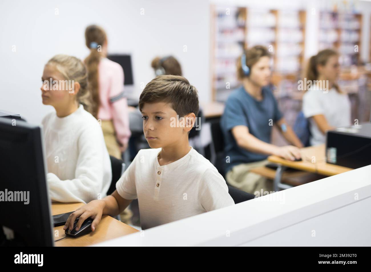Young boy using computer in library Stock Photo - Alamy