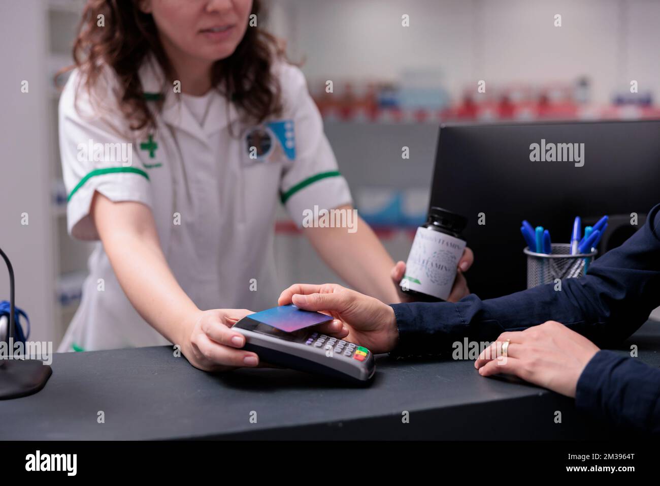 Woman customer putting credit card on pos paying pharmaceutical drugs during pharmaceutical ...