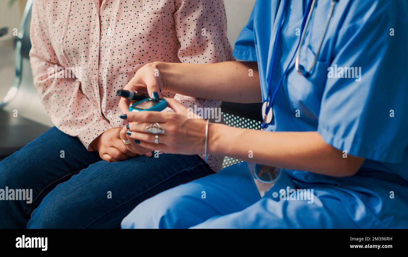 Nurse doing insulin level measurement with glucometer to help patient ...