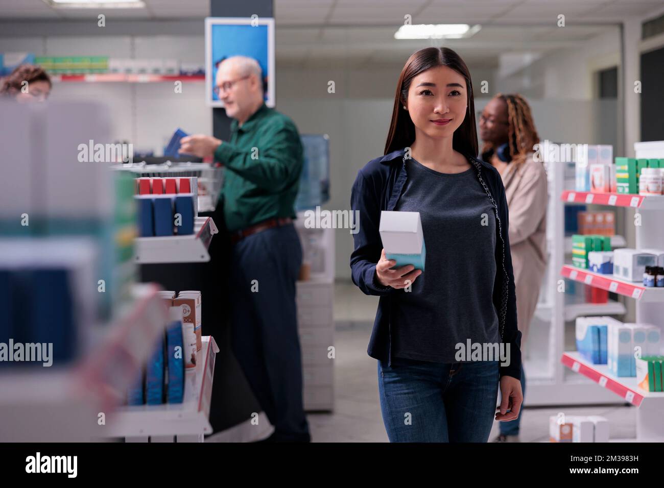 Asian client holding drugs package reading presription before buy it ...