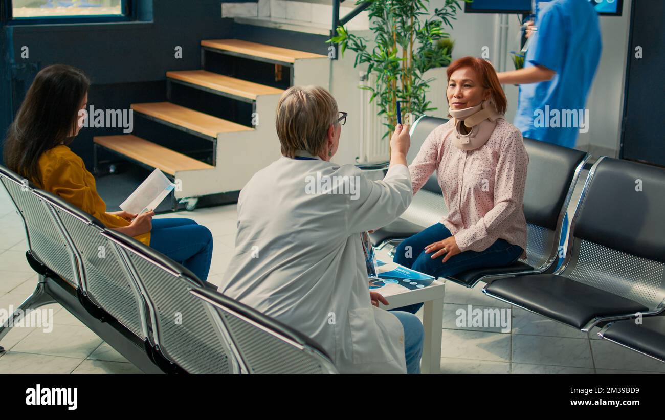 Asian patient with cervical collar doing brain damage exam with old ...