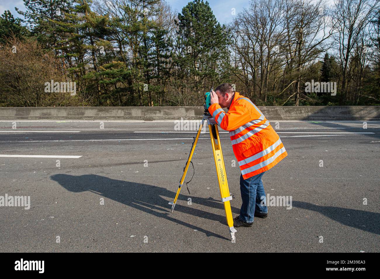 a police officer takes measurements at the scene of a traffic accident ...