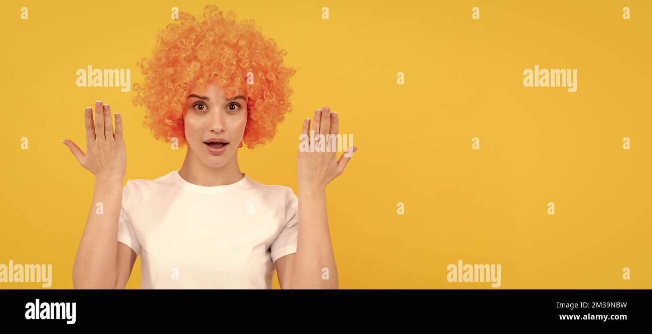 surprised freaky woman in curly clown wig with raised hands, surprise ...