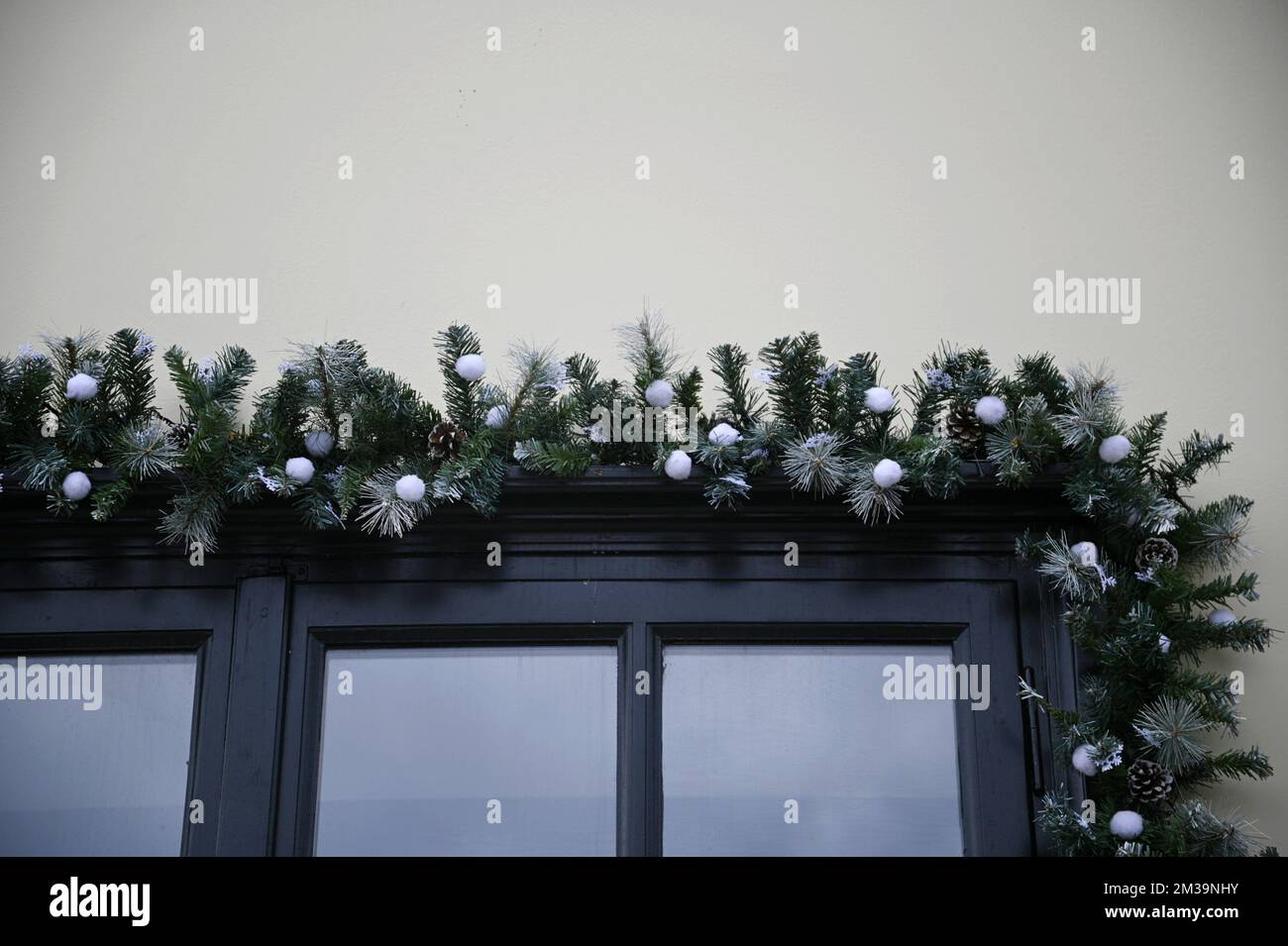 Festive Christmas garland decorations on a Neoclassical building window ...