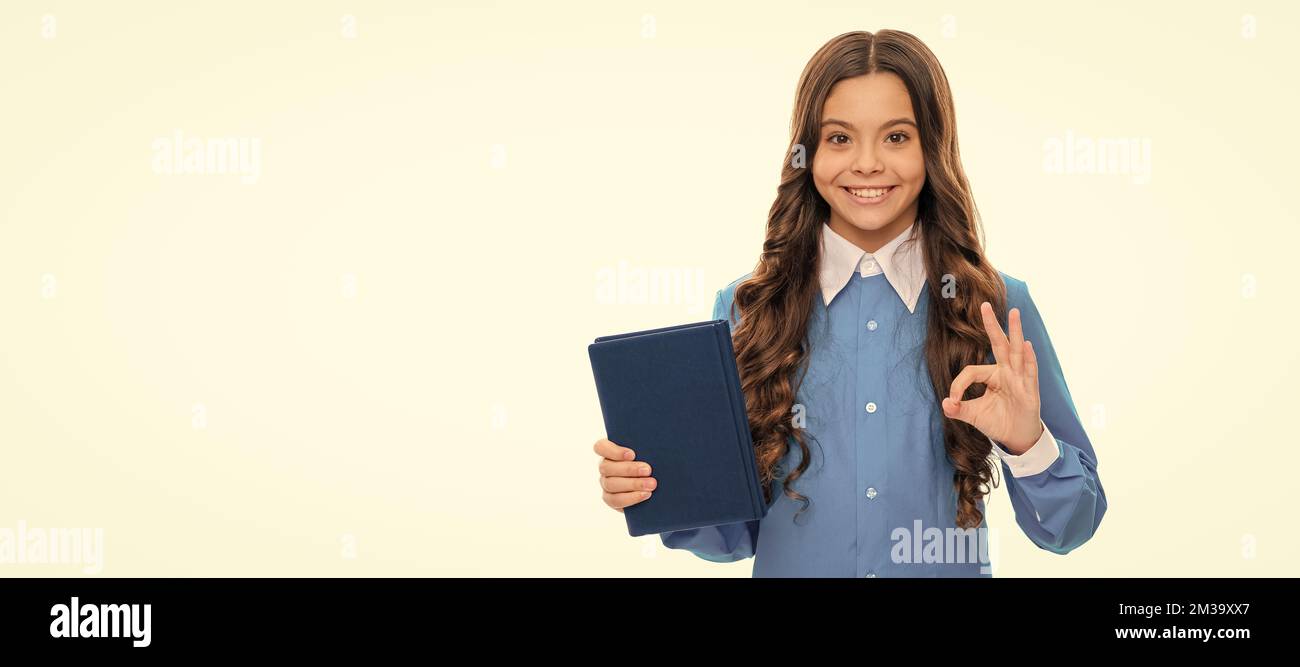 Happy primary school pupil hold library book showing OK sign isolated ...