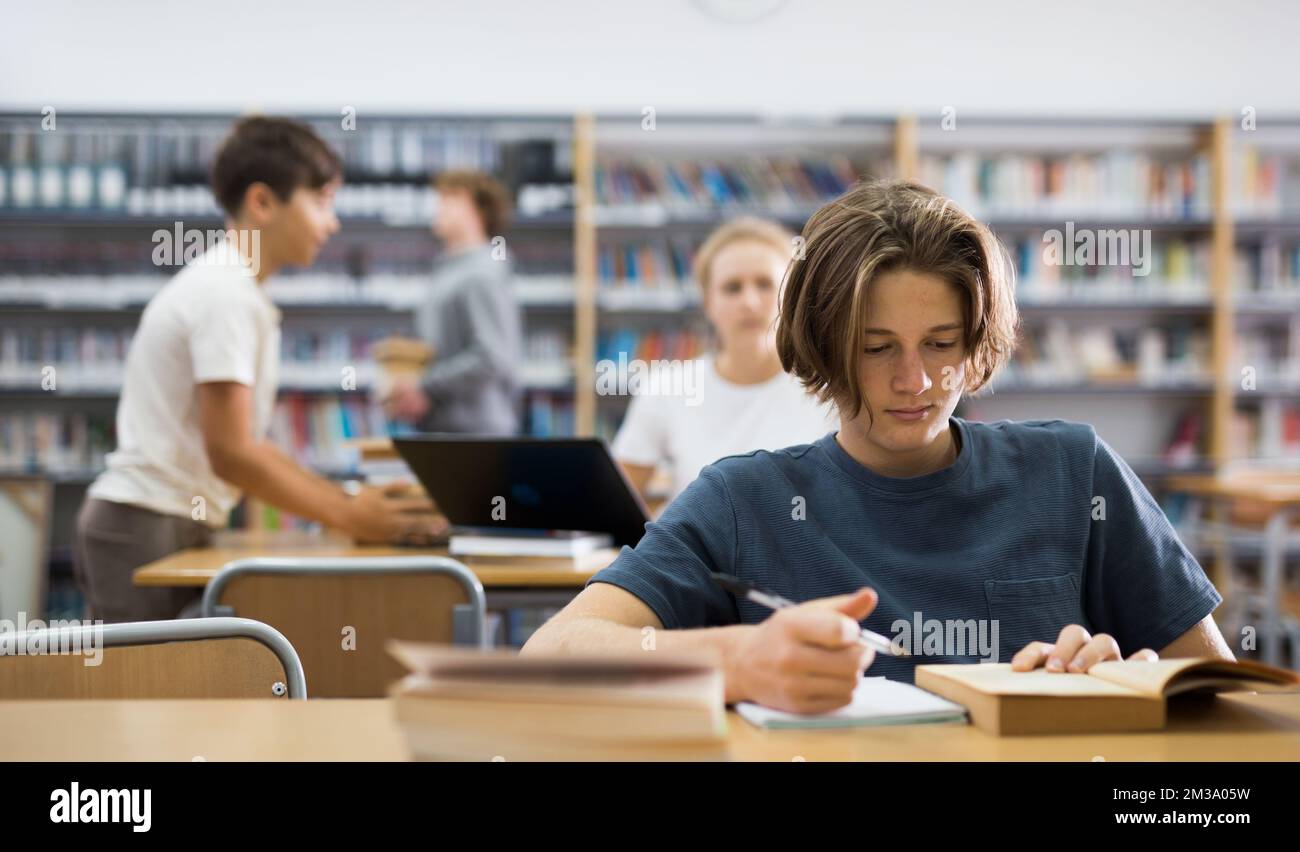 Boy preparing for exams in library Stock Photo - Alamy
