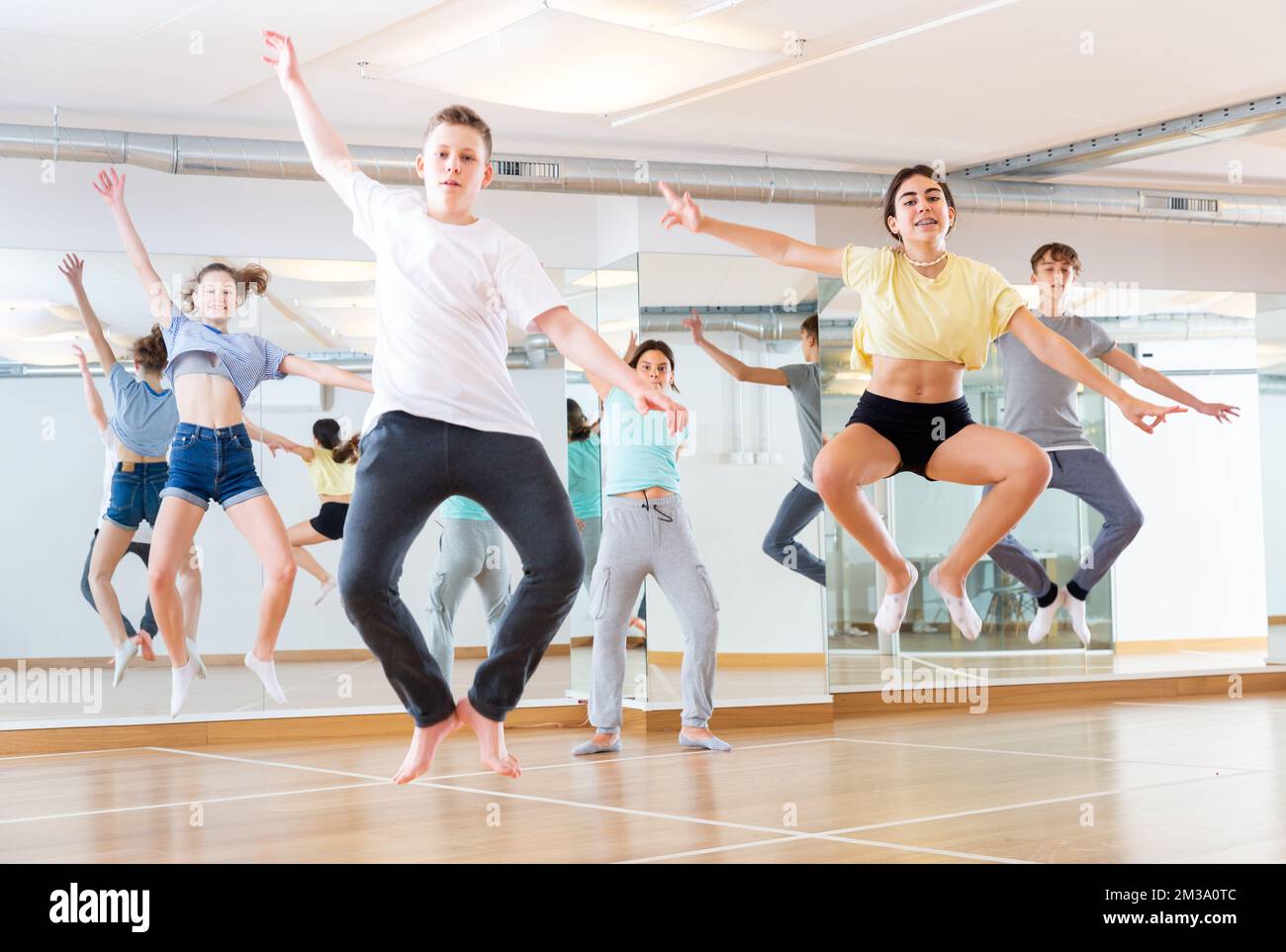 Teenagers jumping together during dance workout Stock Photo - Alamy
