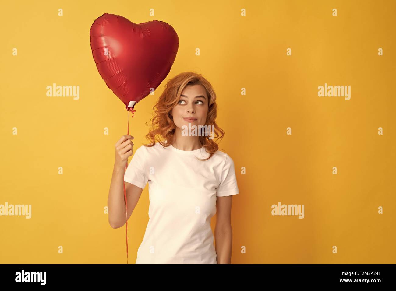 pondering redhead girl with love heart balloon. be my valentine Stock ...