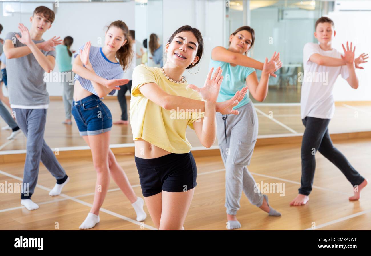 Diligent friendly smiling teenagers learn dance movements Stock Photo ...