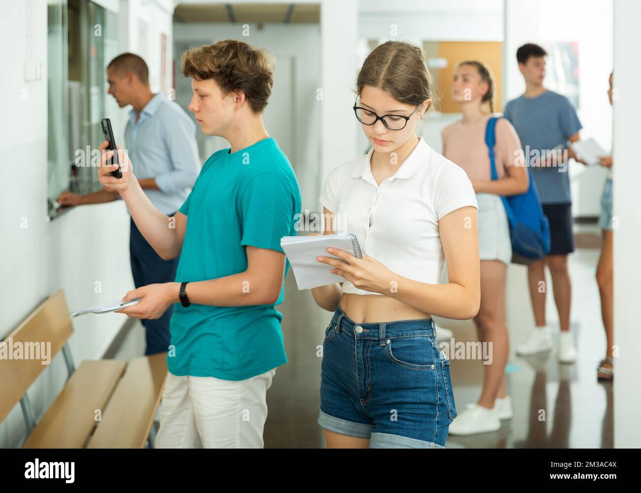 Teenage boy and girl students checking classes schedule Stock Photo - Alamy