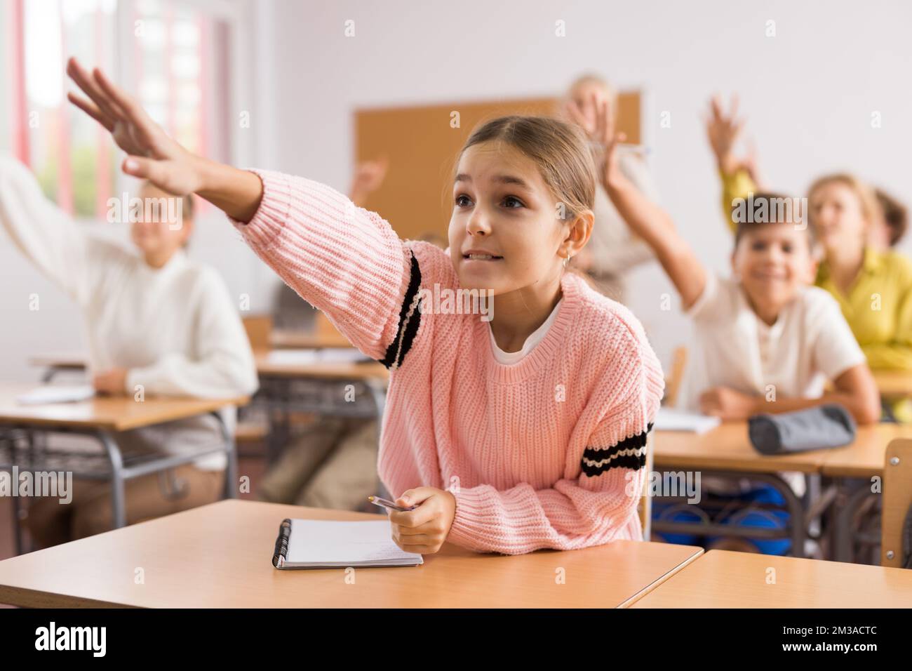 Students raise their hand to answer during lesson in class Stock Photo ...