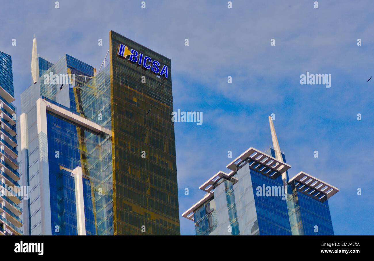 top of buildings one of them with the name of bicsa, behind blue sky ...