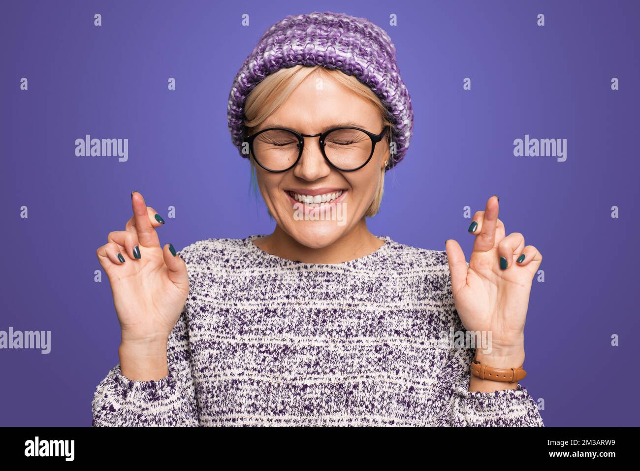 Young caucasian woman with fingers crossing hoping all wishes come true ...