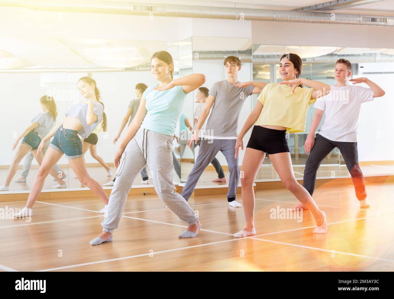 Positive smiling slim teenagers dancing hip hop in class Stock Photo ...