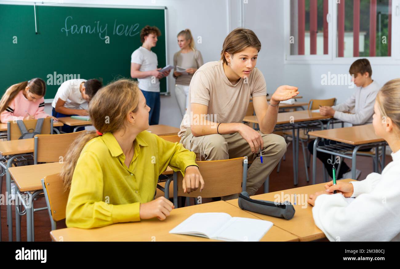 Teenagers resting and talking during recess in classroom Stock Photo ...