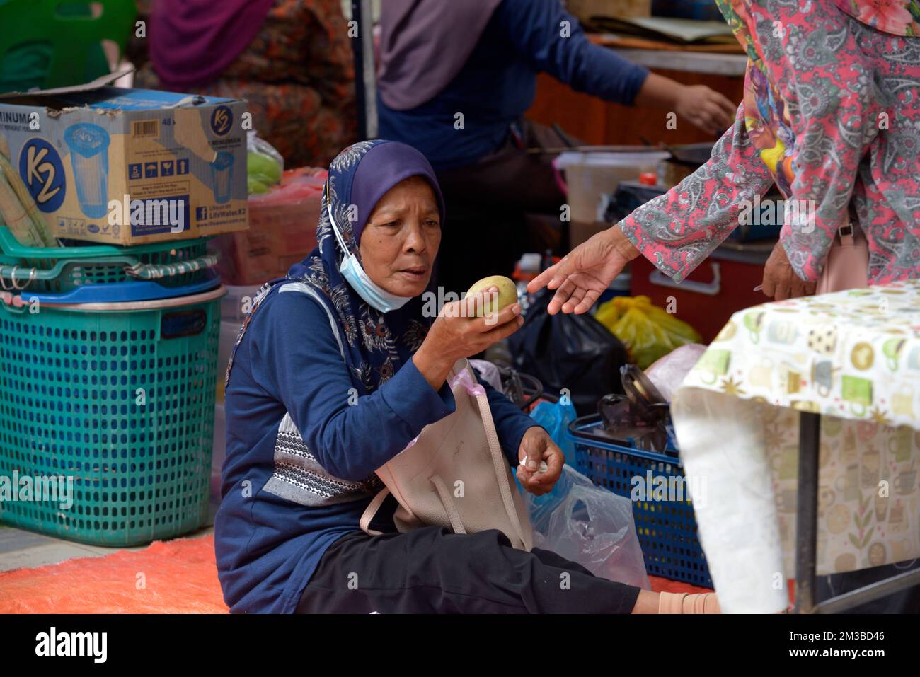 An indigenous Bajau woman selling food at the Sunday market in Kota ...