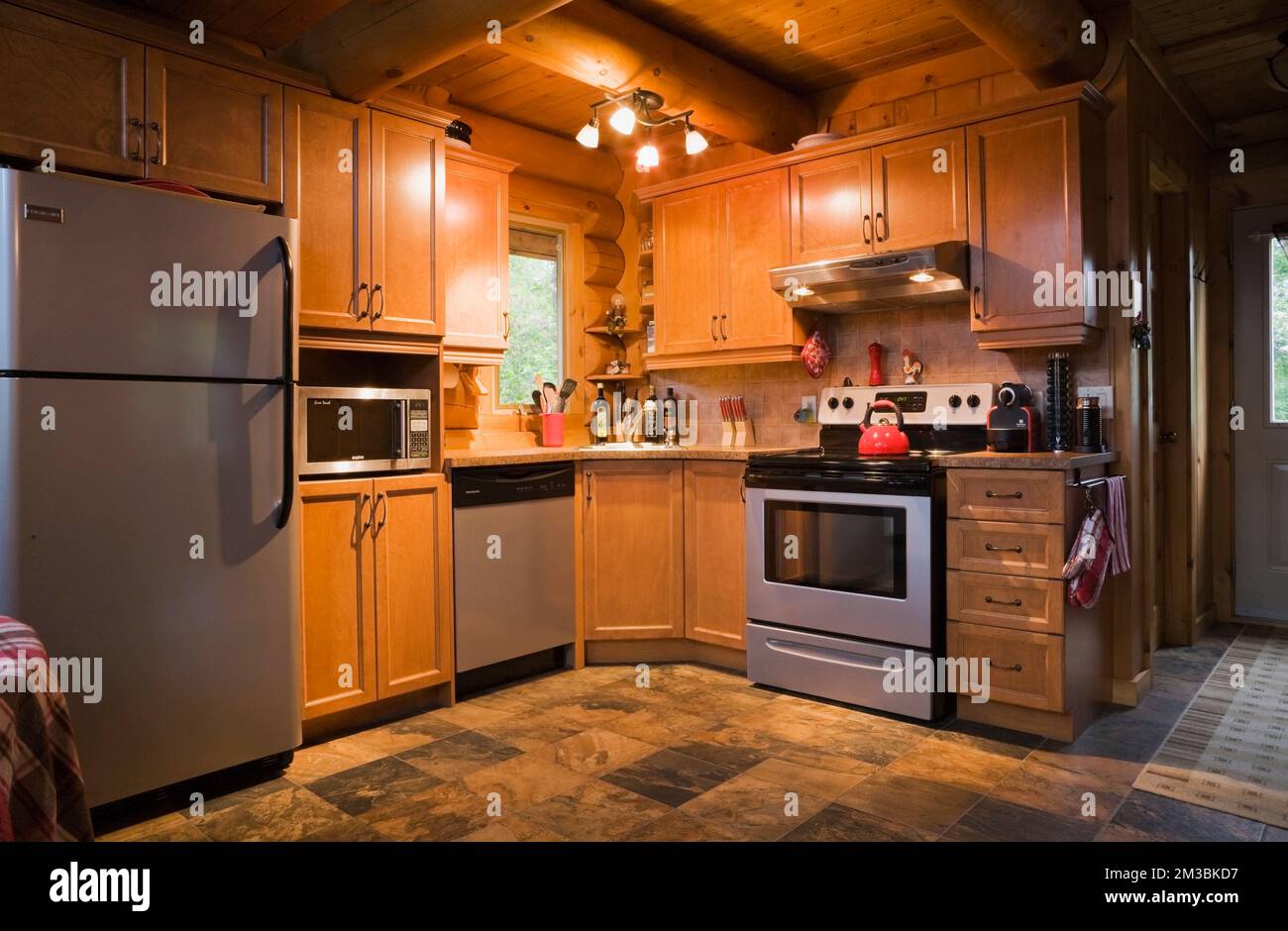 Wooden shaker style cabinets and modern appliances in kitchen with ...