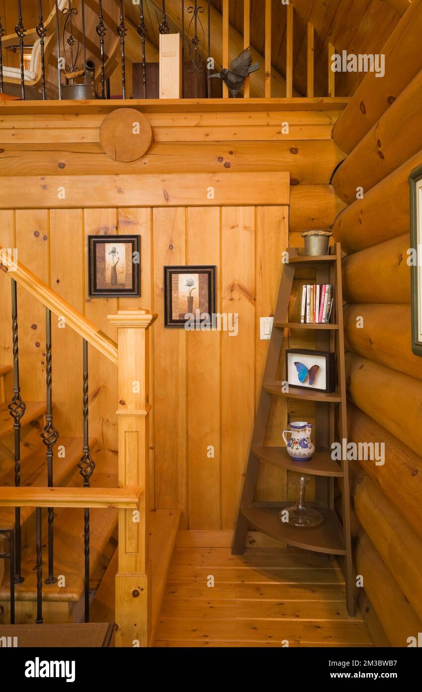 Corner bookcase next to wooden staircase with wrought iron baluster ...