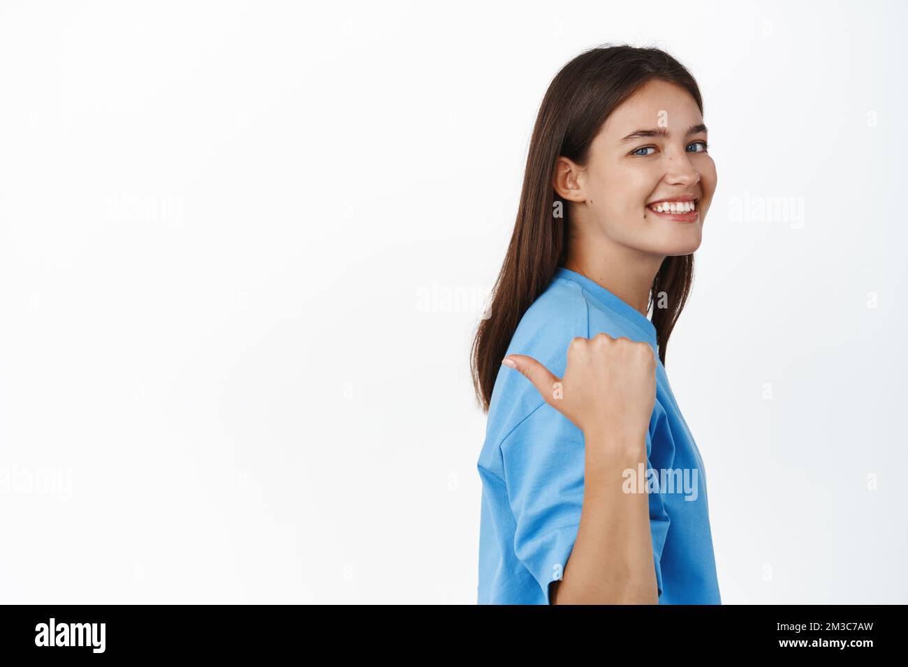 Image of smiling cute healthy girl pointing finger left, showing promo ...