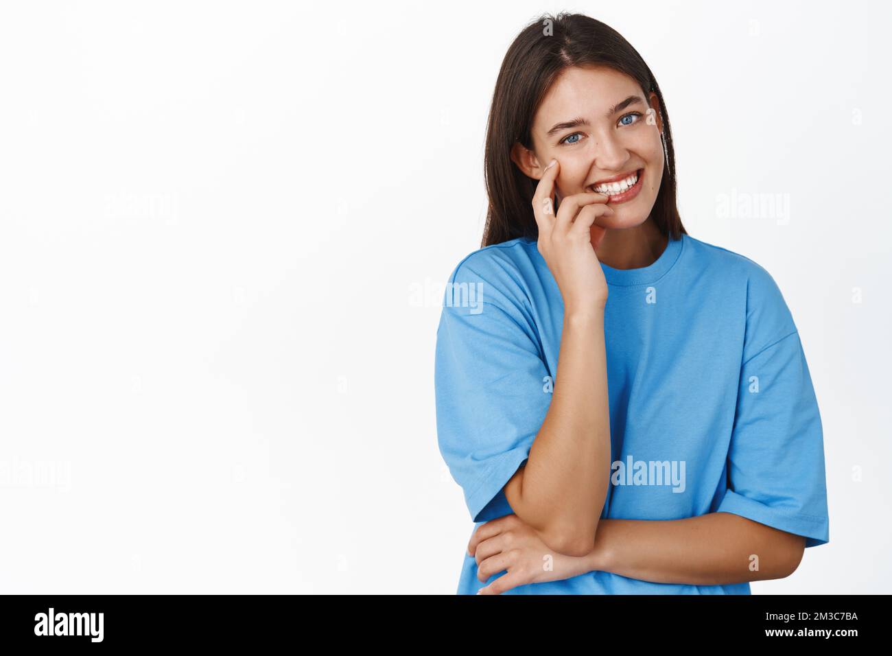 Portrait of beautiful millennial woman laughing and smiling, touching ...