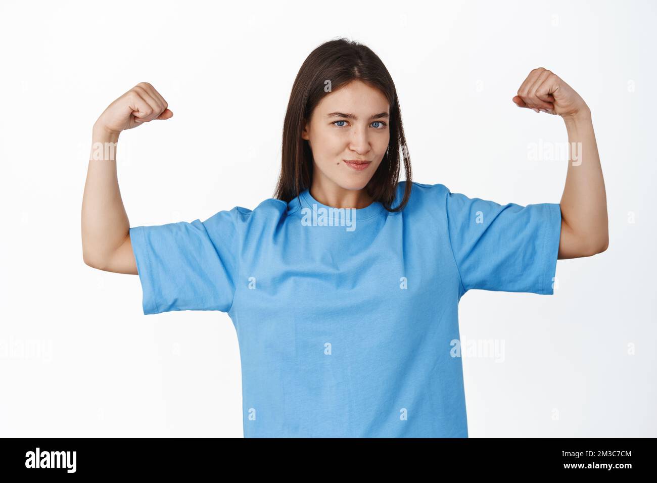 Young strong sassy girl, showing power gesture, flexing biceps, workout ...