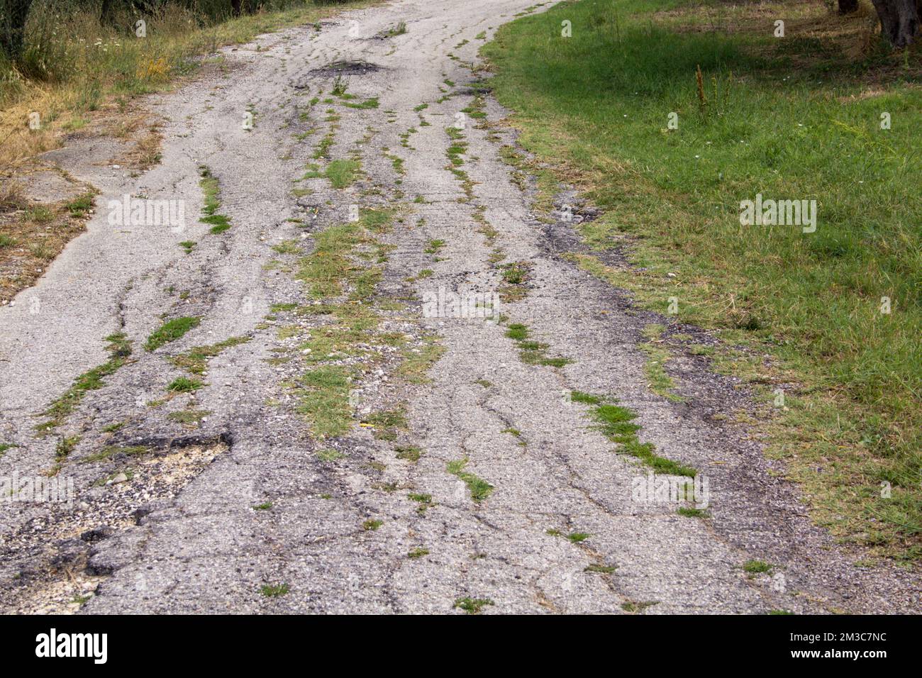 Image of a rough and completely broken and abandoned country road Stock Photo - Alamy