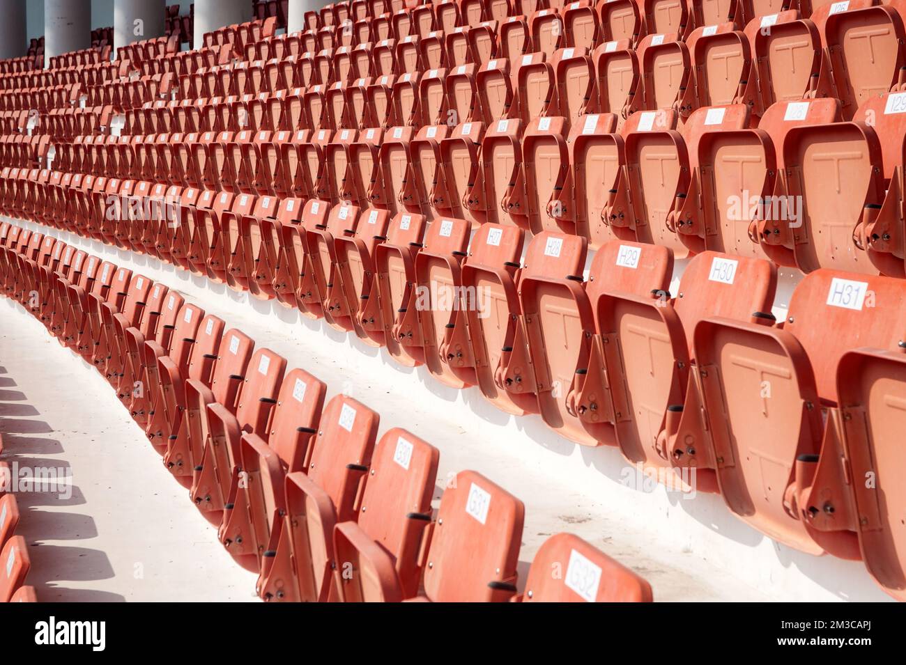 Row of orange color on stadium seats in background Stock Photo - Alamy