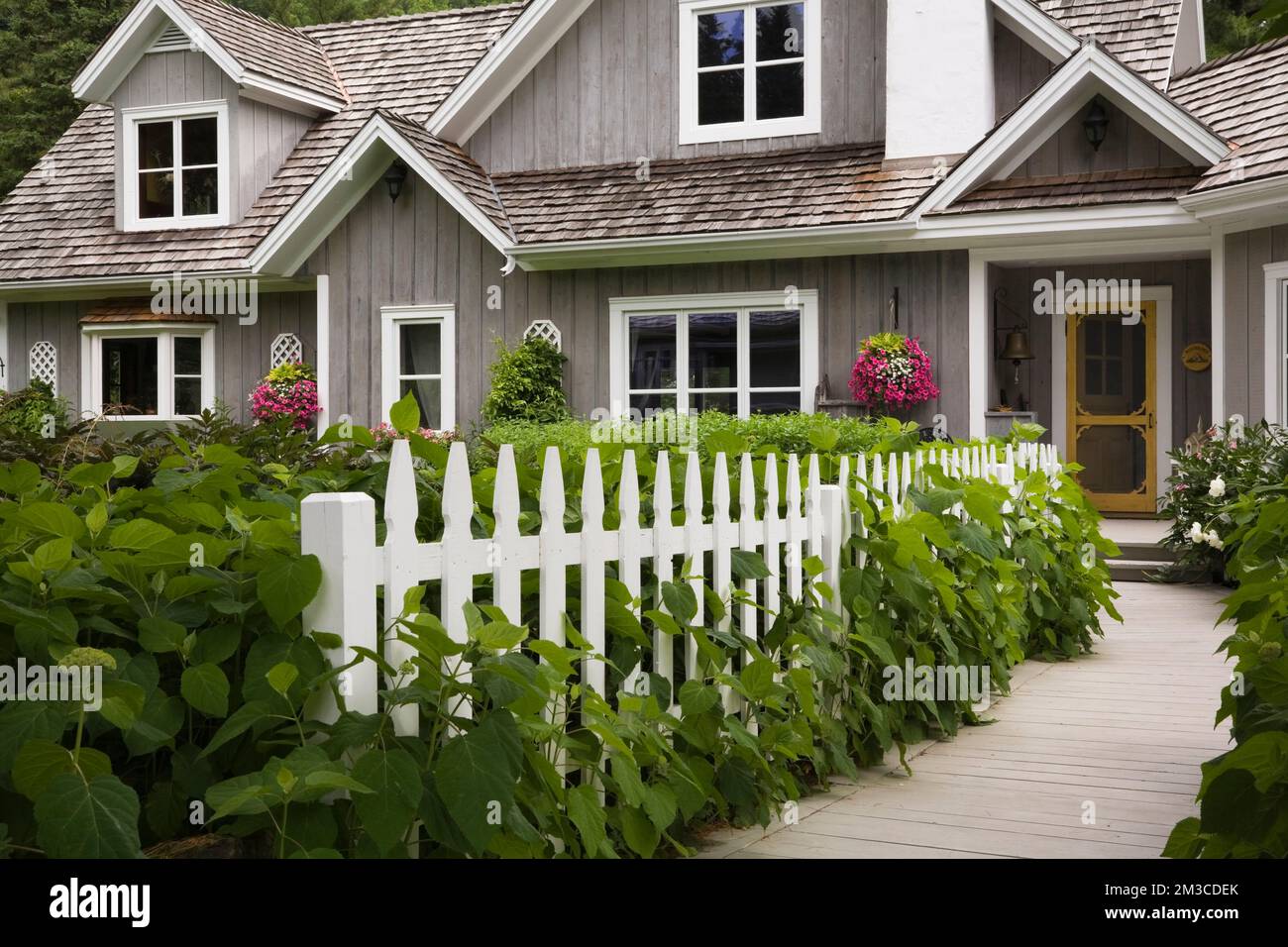 New Hampton cottage style home with landscaped front yard and wooden ...