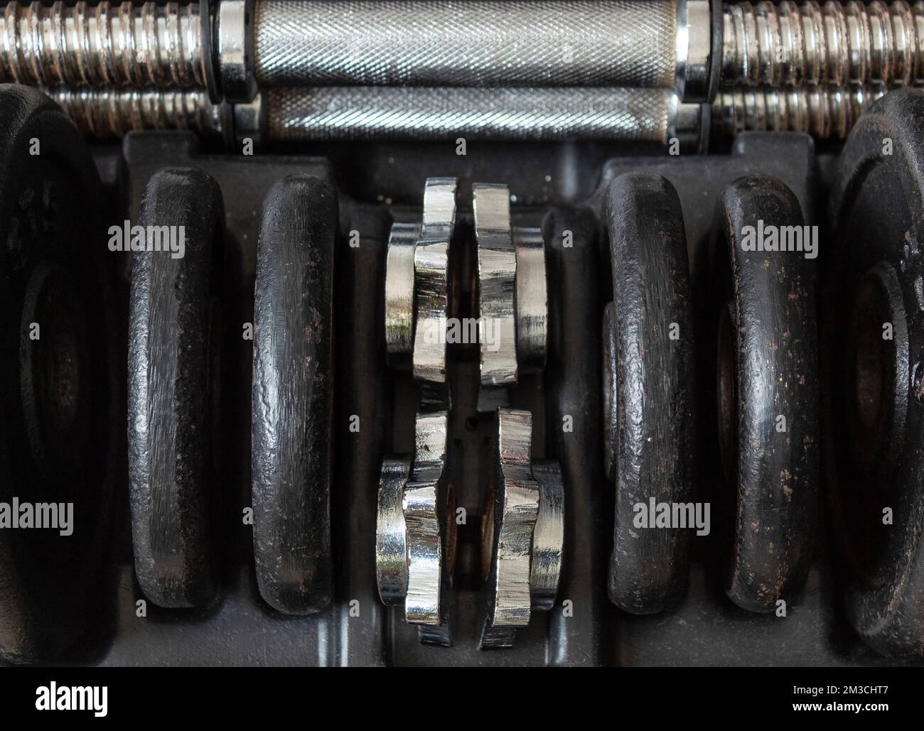Closeup to an old dumbbell set, with iron gear, iron bar and discs ...