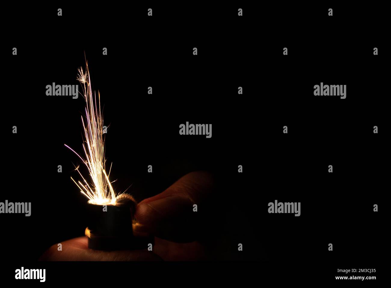 Closeup to hand igniting fire lighters with black background. Energy ...
