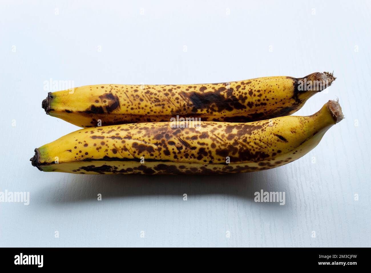 Close up to a two yellow freckled bananas in horizontal form over a ...