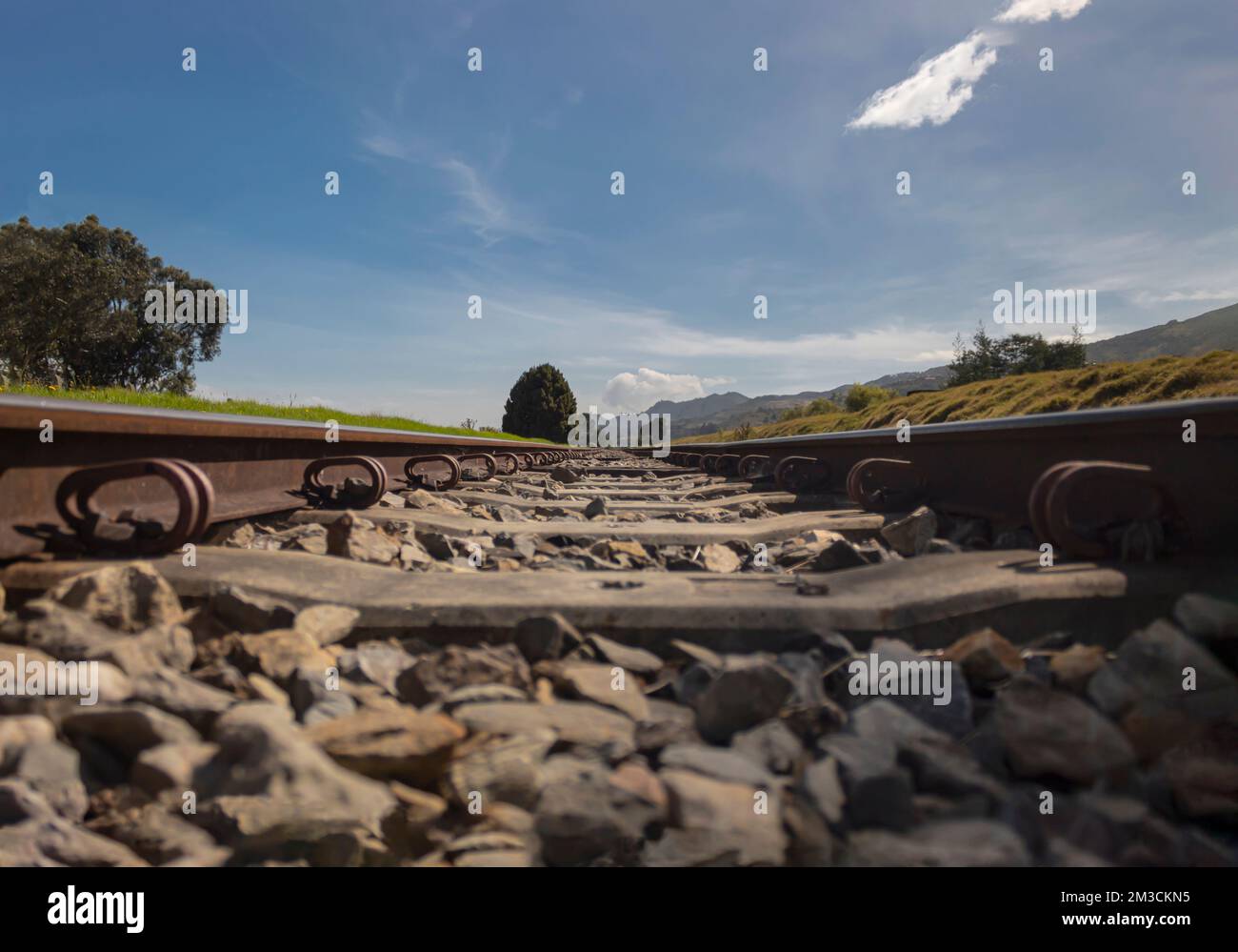 Ground view of an old railroad crossing a green country field with ...