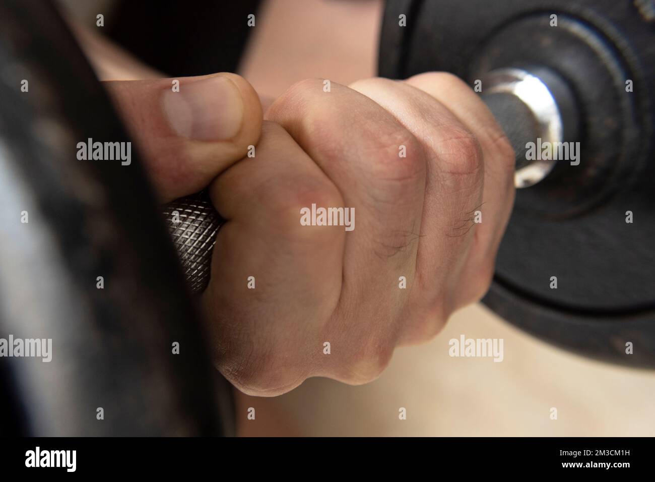 Closeup to male hand squeezing an iron 5 dumbell. Ideal for fitness ...