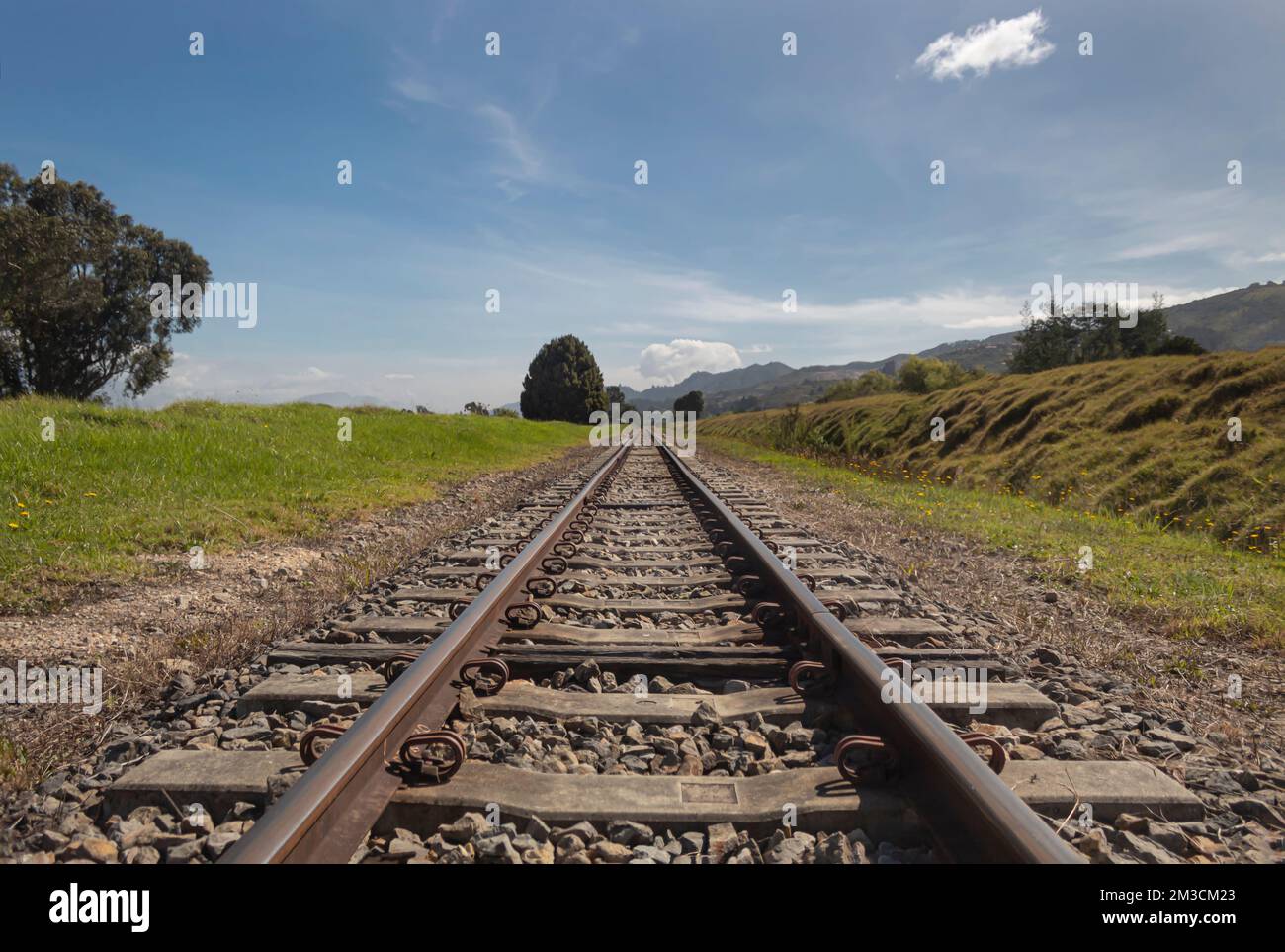 Closeup to an old railroad crossing a green countryfield with a lonely ...