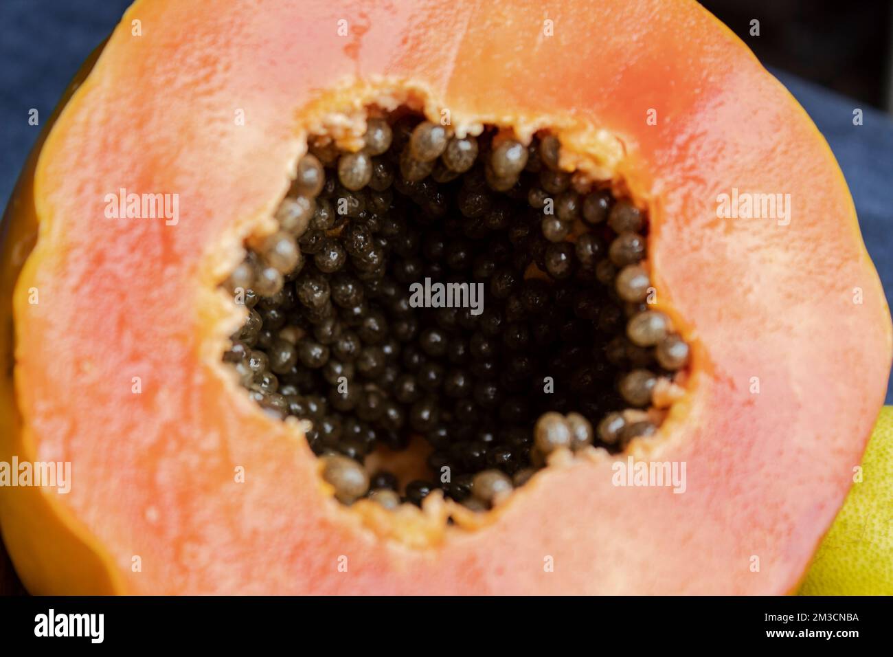 Macro photography to asliced orange fresh papaya with seeds inside ...
