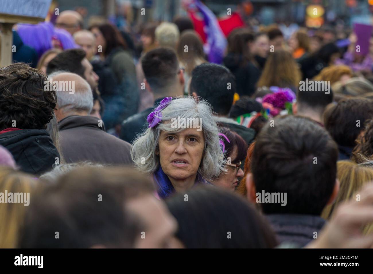Closeup to an Old grey hair woman with violet ribbon and bun in middle ...