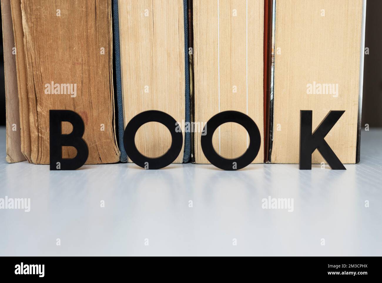 Close up to BOOK black lettering sentence over white table and books ...