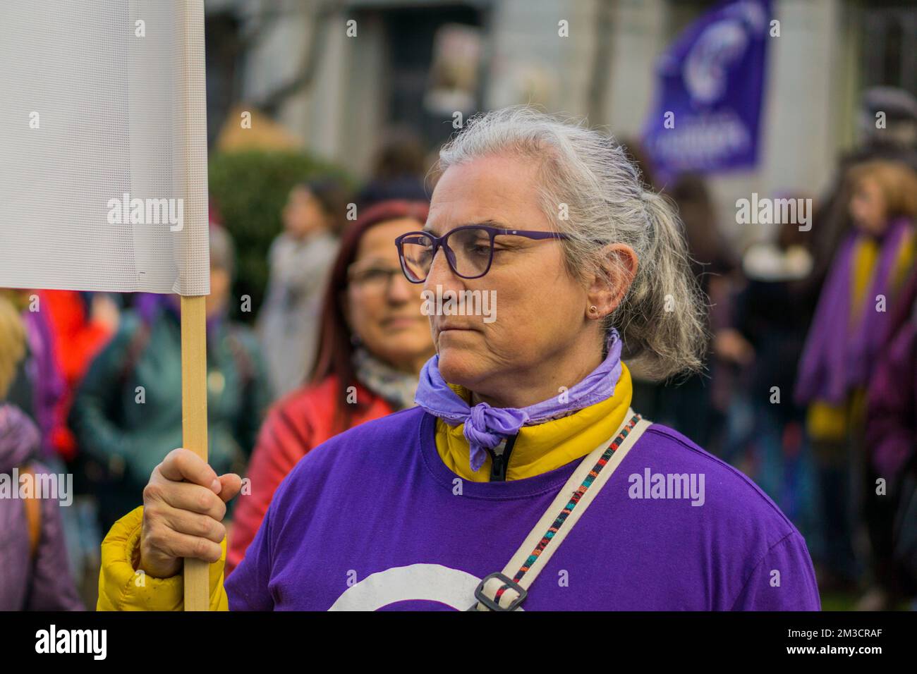 An old Woman with black glasses holding a protest sign during 8M ...