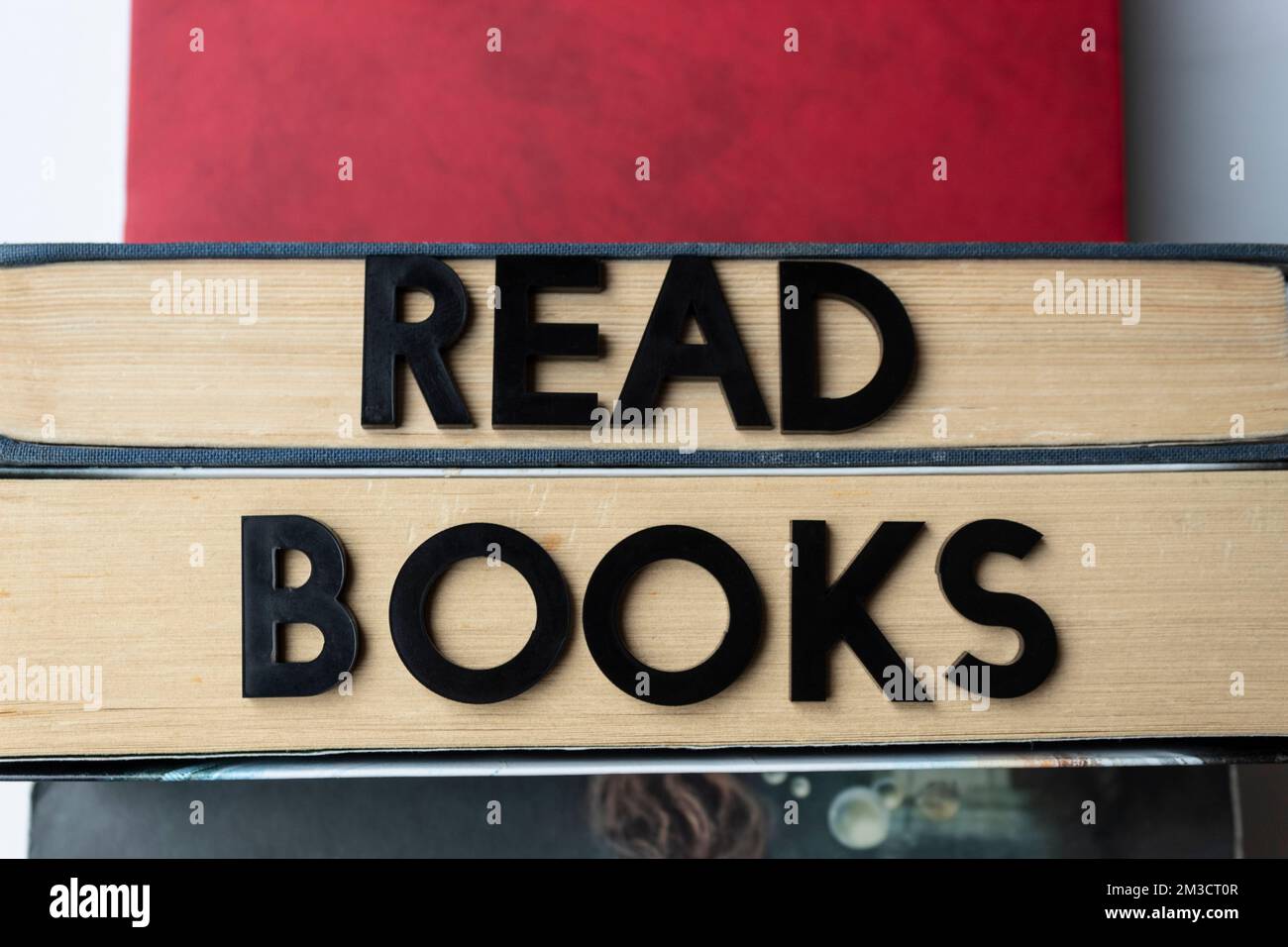 Close up to READ BOOKS black lettering sentence over books fore edge ...