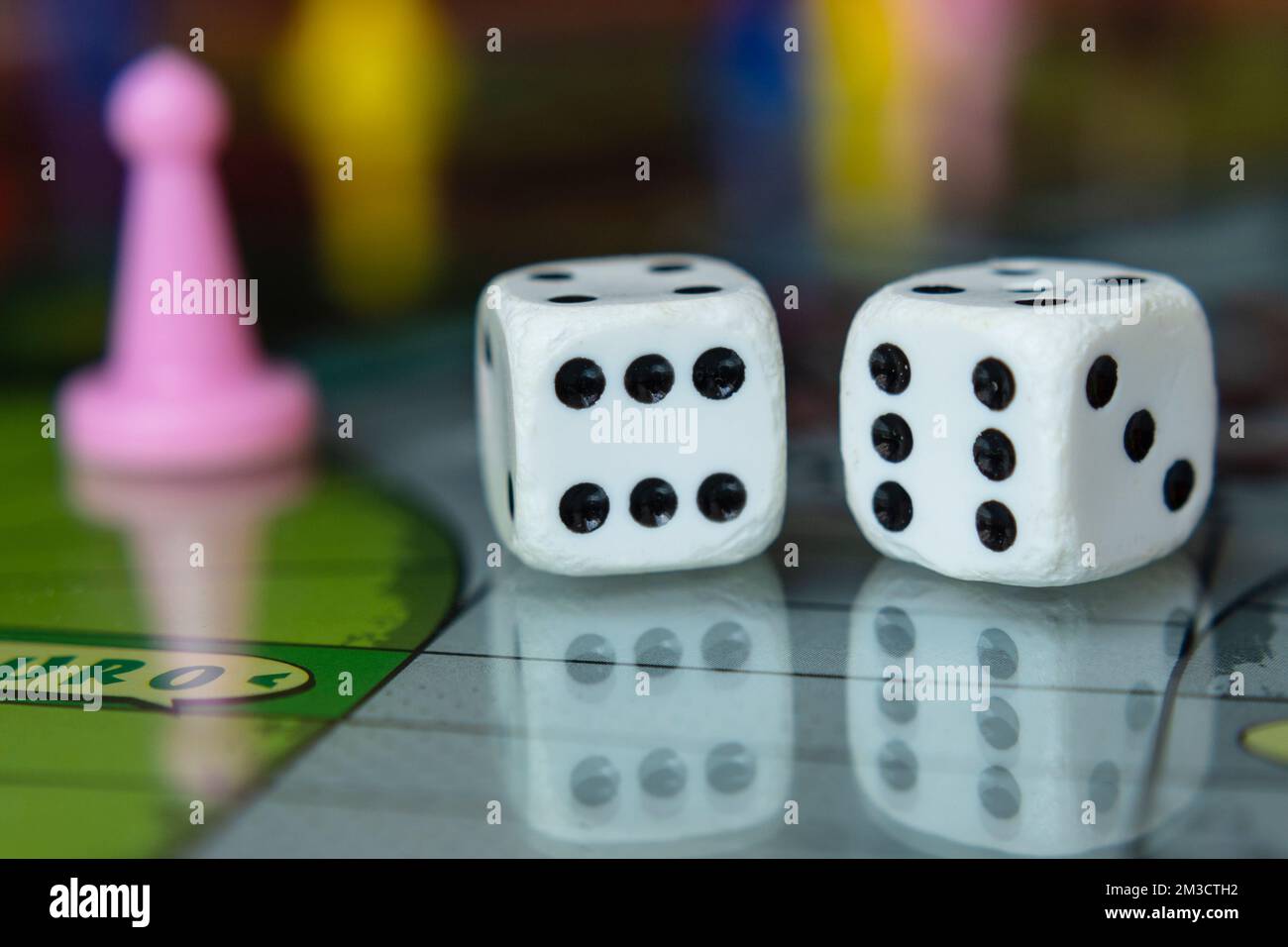 Closeup to a double six old white dices with pink pawn over Colombian ...