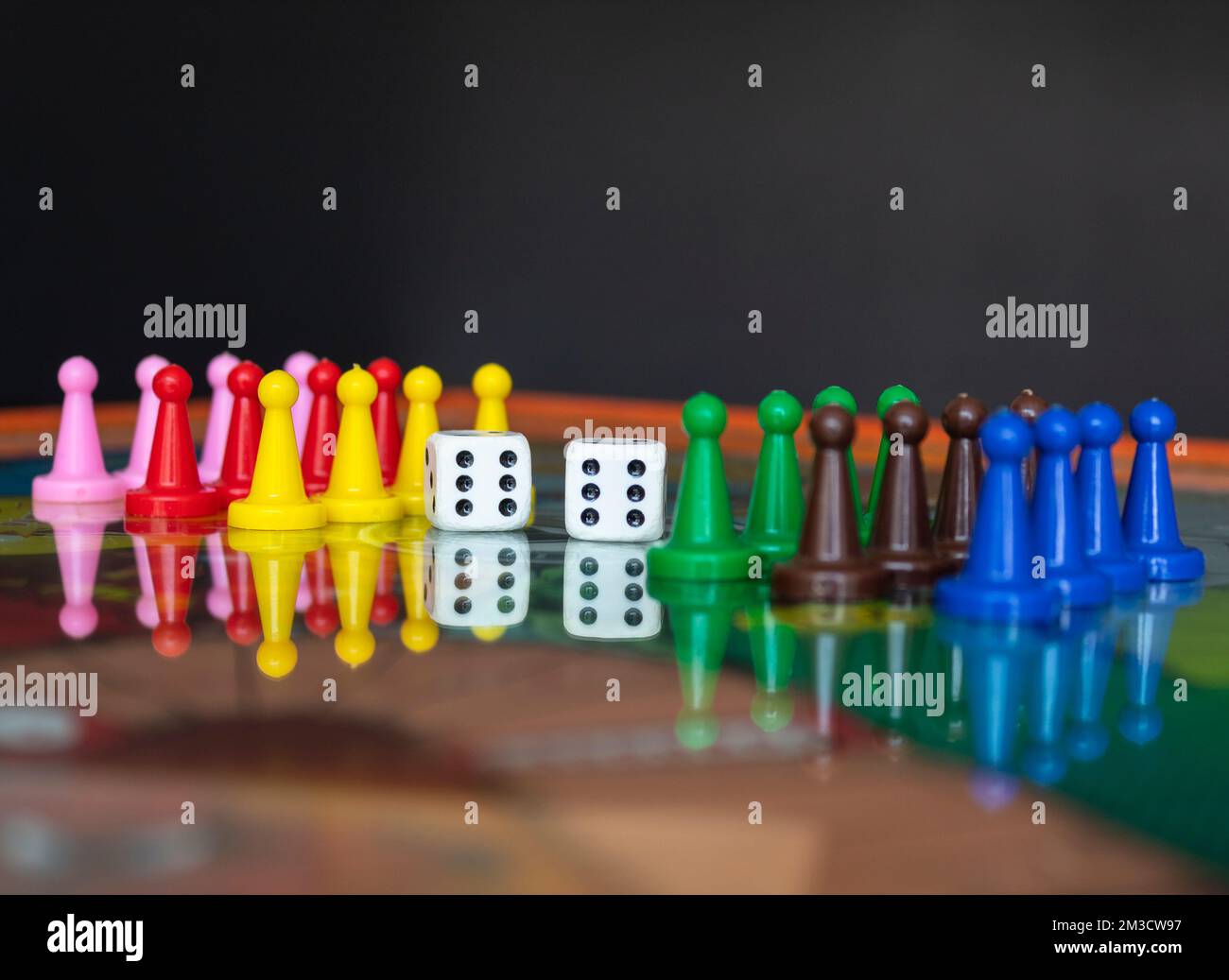 Closeup to a double six white dices with color pawns over a board game ...