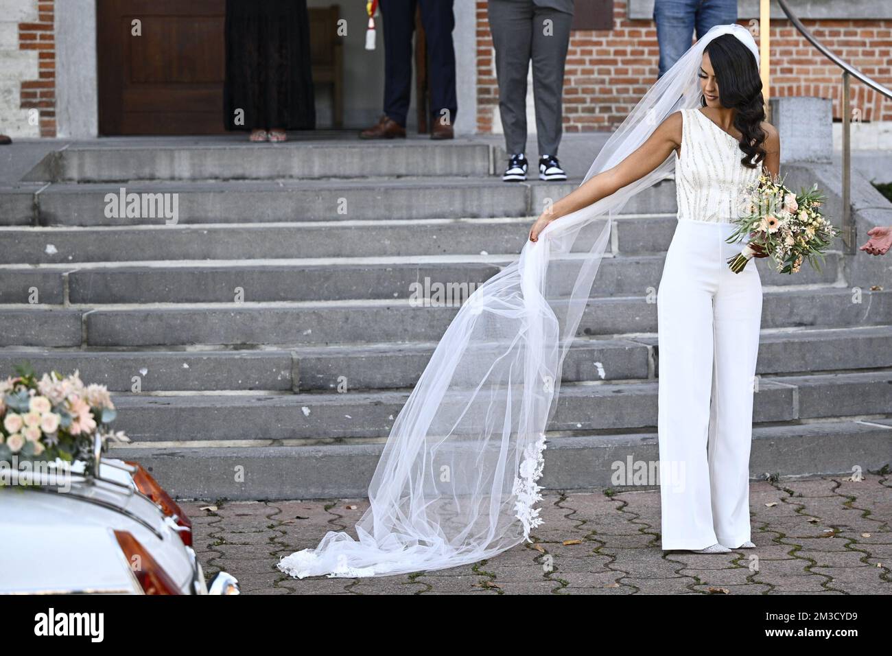 Evenepoel's partner Oumaima Oumi Rayane, wearing a white top and white ...