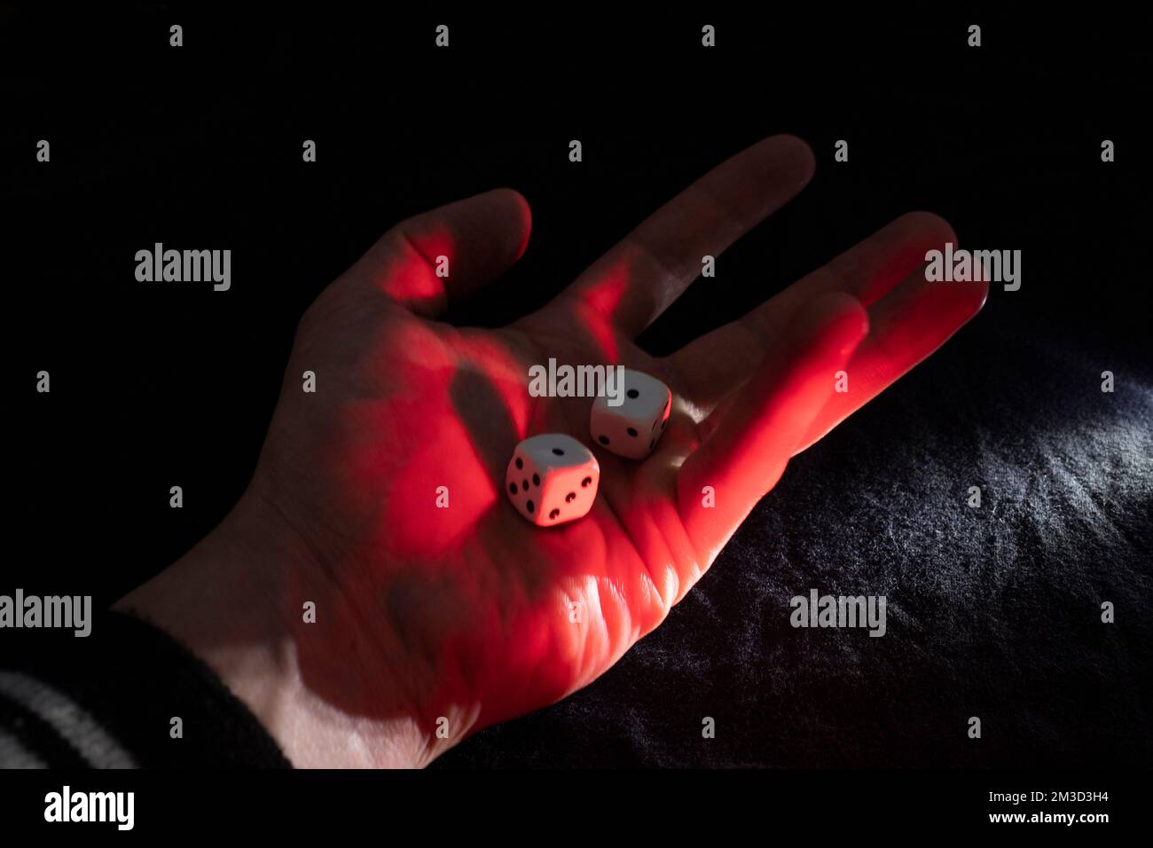 Closeup to a male hand holding old dice with double one number ...