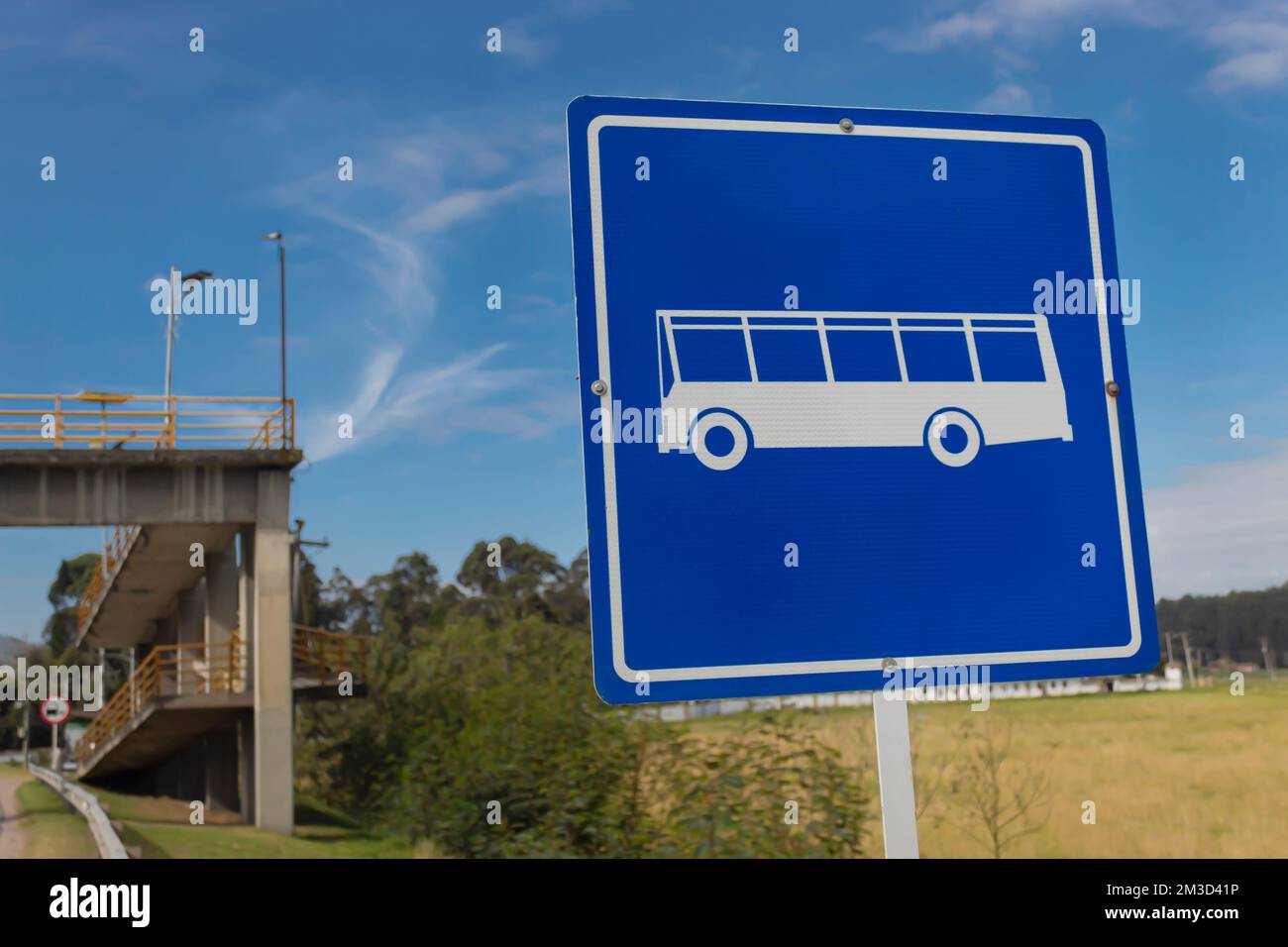 Blue bus station traffic signal in countrifield with a peatonal brige ...