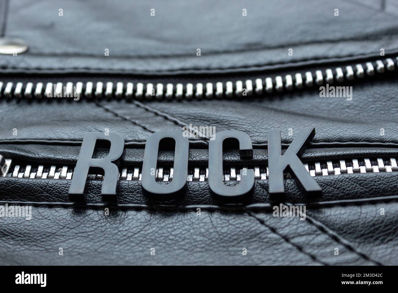 Closeup to a ROCK black lettering word over a black biker leather ...
