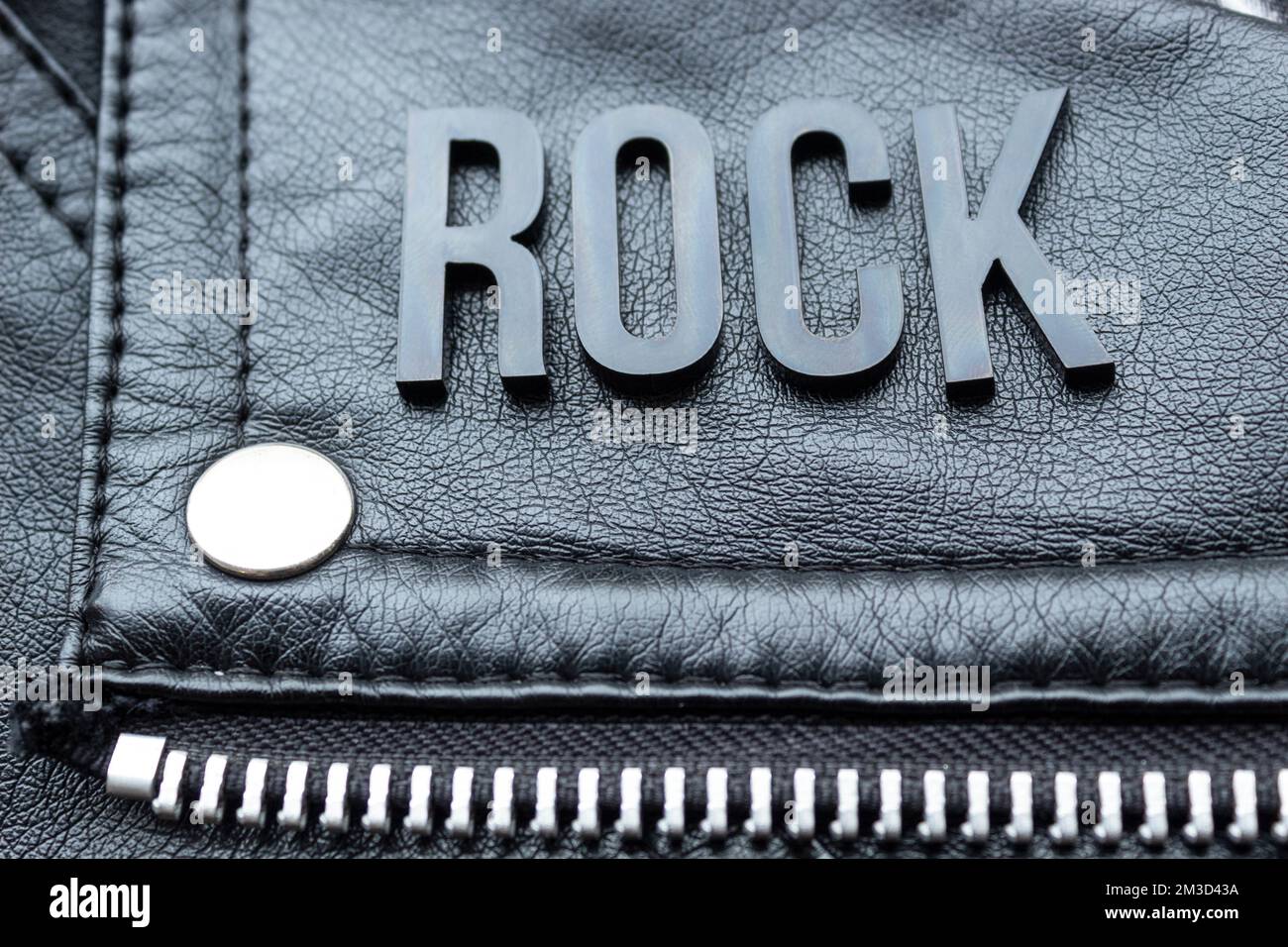 Closeup to a ROCK black lettering word over a black biker leather ...