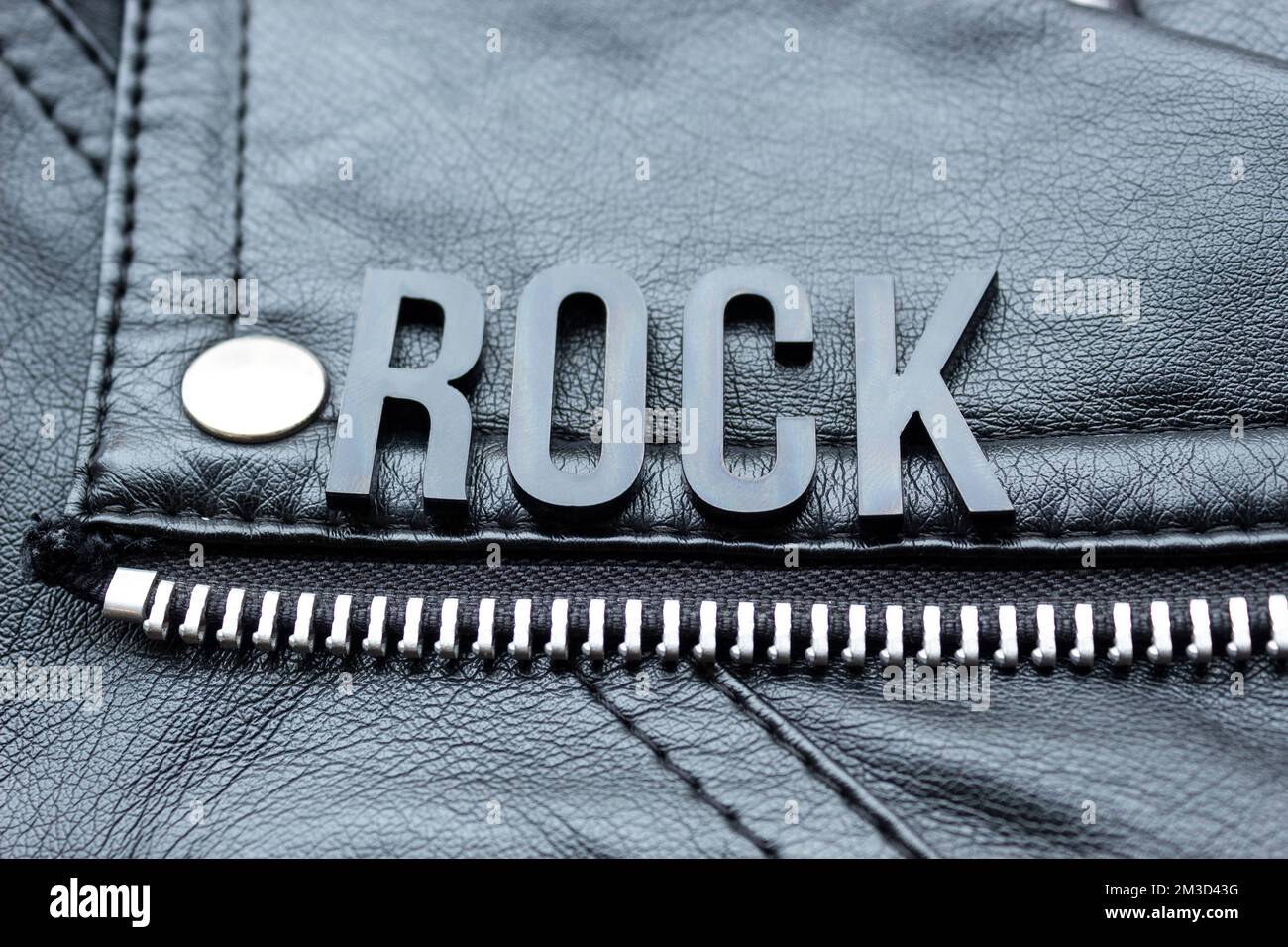 Closeup to a ROCK black lettering word over a black biker leather ...