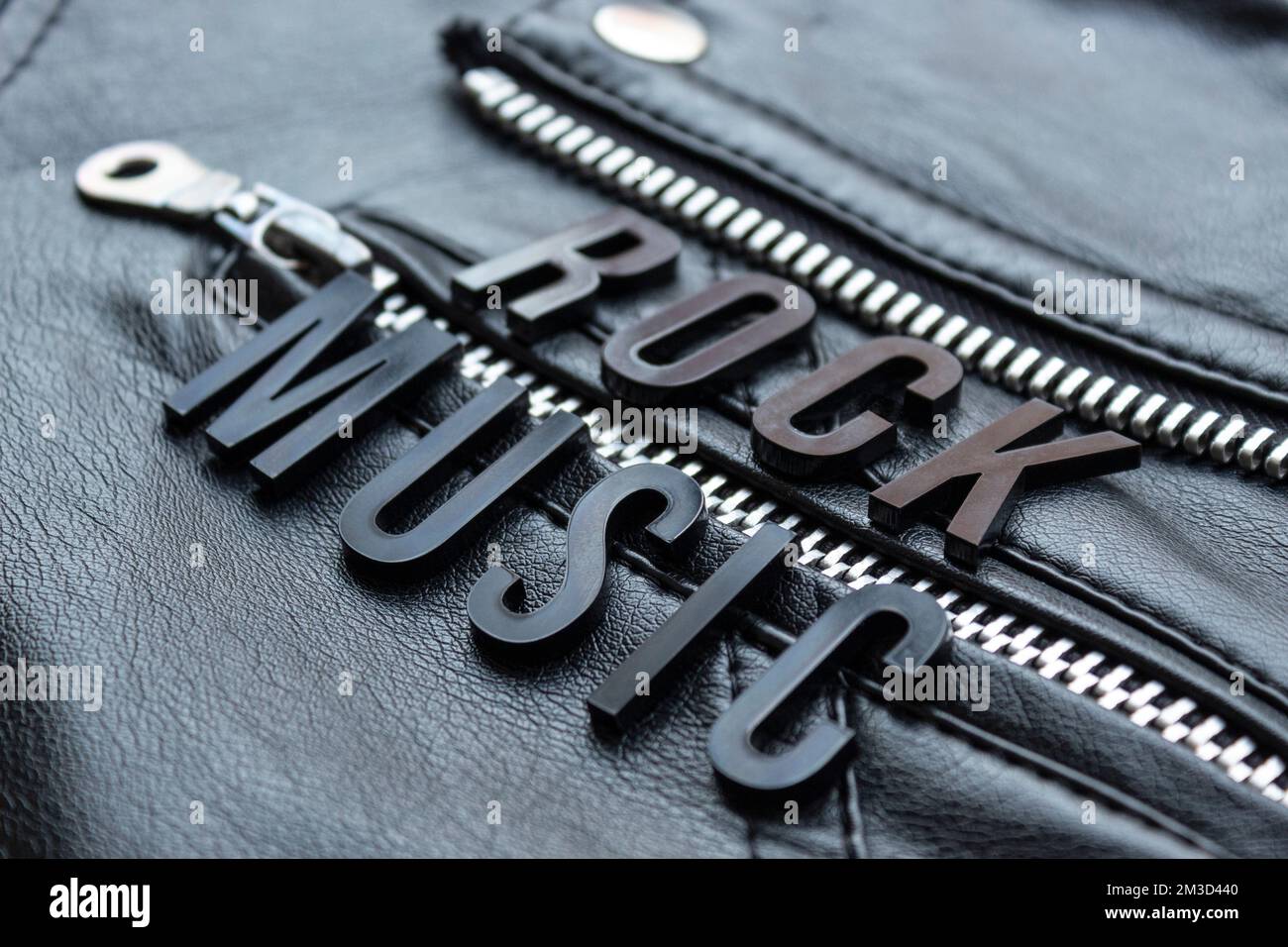 Closeup to a ROCK MUSIC black lettering word over a black biker leather ...